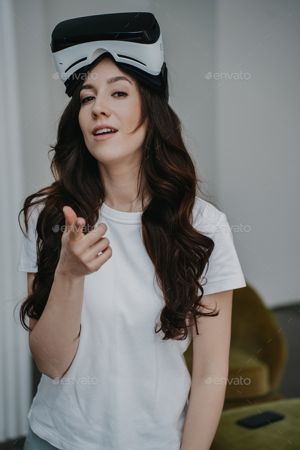 Creative woman with VR headset gestures in mid-explanation, immersed in ...