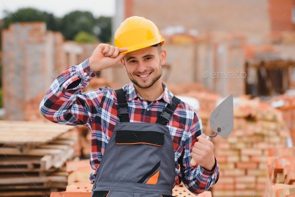 construction mason worker bricklayer installing red brick with trowel ...