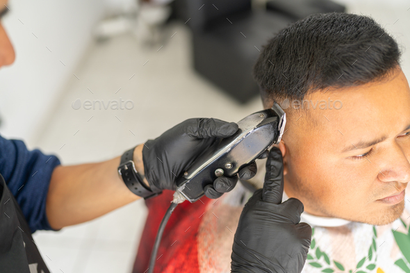Barber cutting hair accurately with an electric razor Stock Photo by ...
