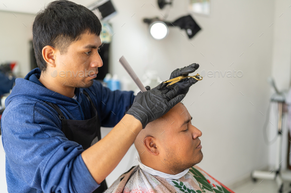 Barber working concentrated cutting the hair of a client Stock Photo by ...