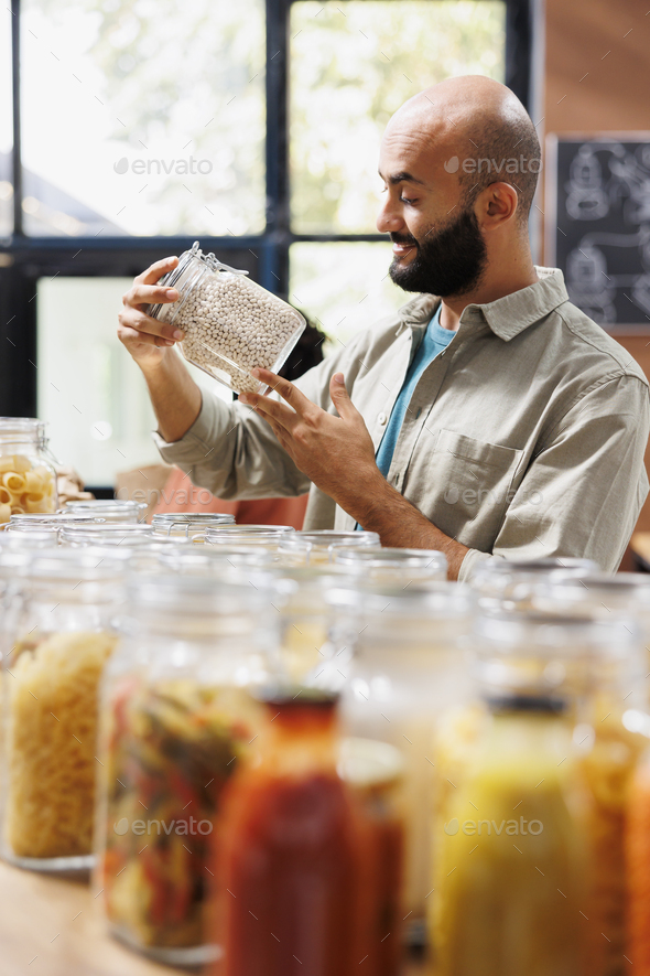 Man closely admires a filled glass jar Stock Photo by DC_Studio | PhotoDune
