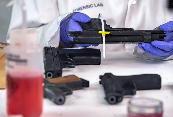 Close up of forensic science evidence box containing gun from crime ...