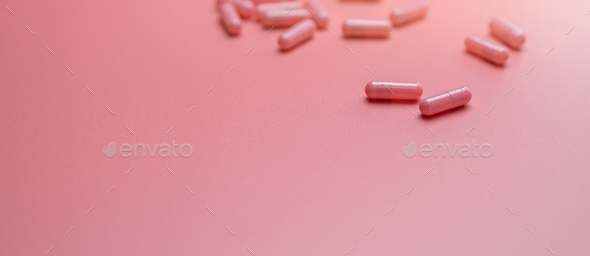 Pink capsules pill spread on pink background. Vitamins and supplements ...