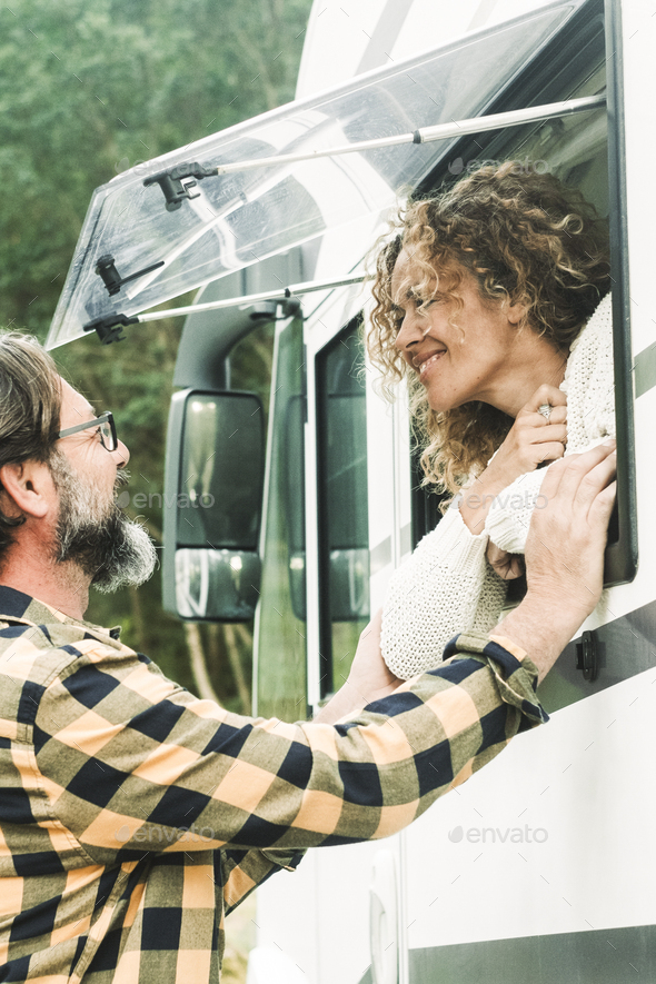 Happy adult couple enjoy travel destination with motorhome camper van ...