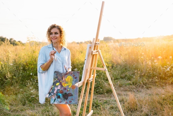 Beautiful female artist painting with watercolor paints. Creativity and ...