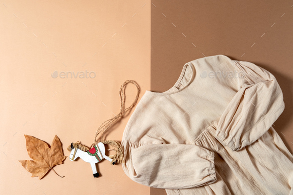 Top view flat lay beige children dress on beige and brown background ...