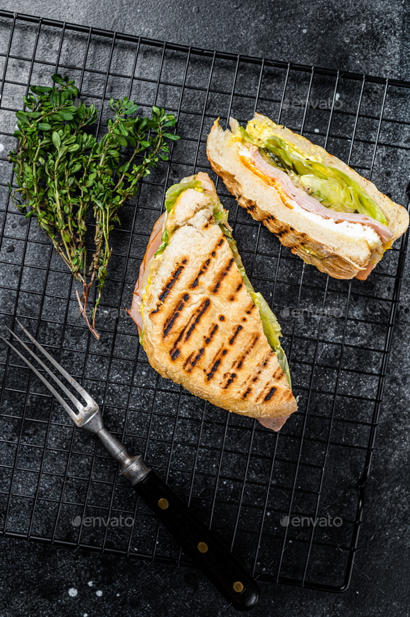 Grilled panini with Prosciutto ham, salad and cheese. Black background ...