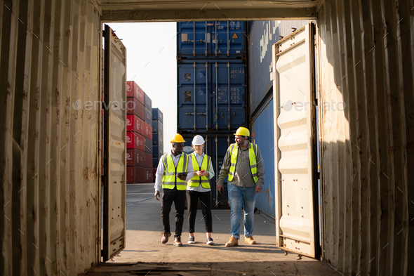 Group of workers in an empty container storage yard, Stock Photo by wosunan