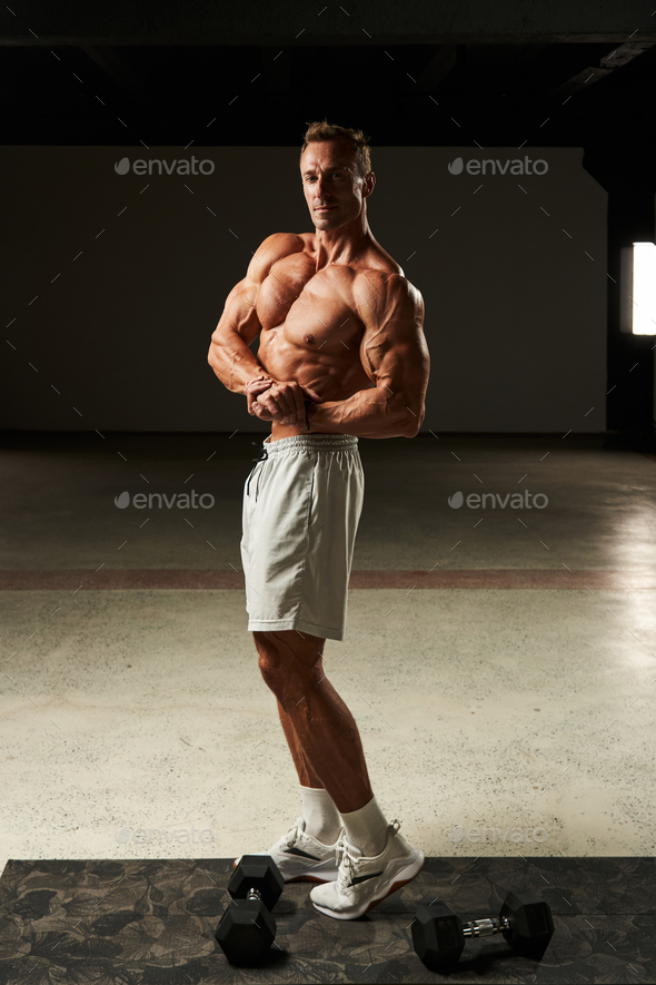 Muscles ripple with elegant precision, a young, muscular man displays ...