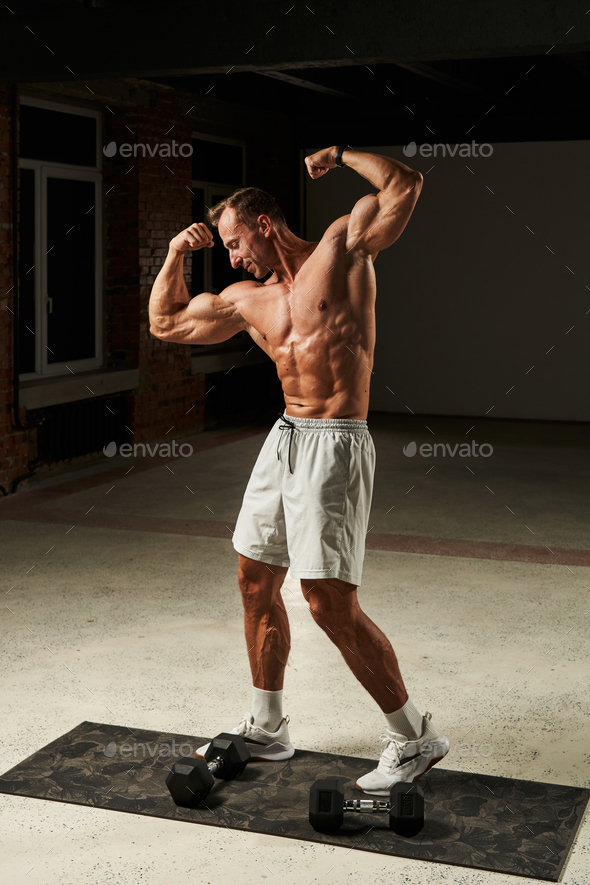 Like a modern-day Titan, a young, muscular man's muscles ripple with ...
