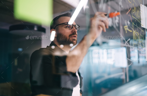 Focused man standing with marker inside meeting room Stock Photo by ...
