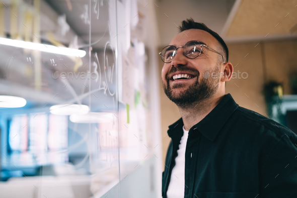 Cheerful man standing near transparent board with calculations Stock ...