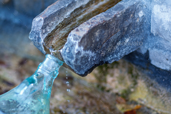 collecting safe spring mineral water from source in mountain for human ...