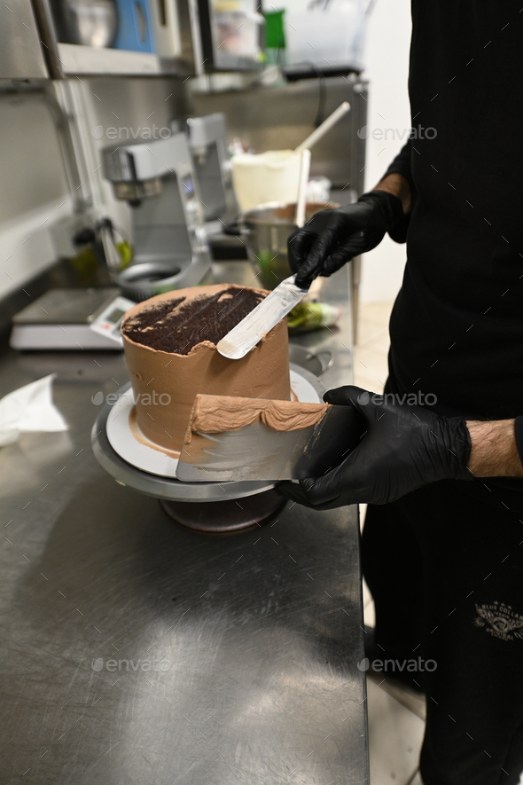 pastry chef smooth level sculpt cream on frosted layered dark chocolate ...