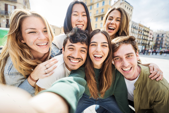 Multicultural young people smiling together at camera outside Stock ...