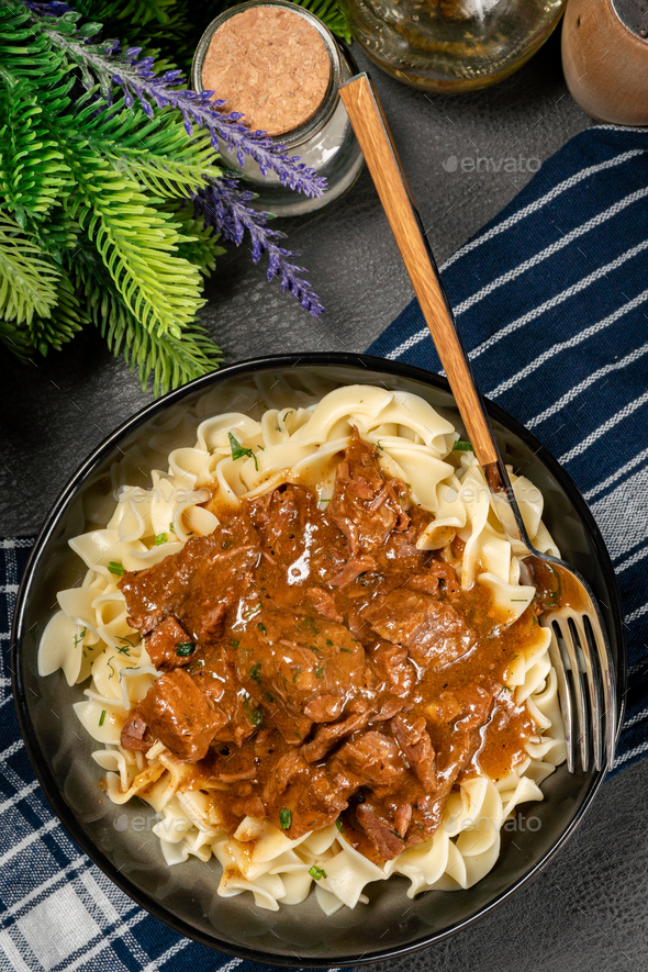 Pasta with beef stew in black bowl. Stock Photo by foto_pstryki | PhotoDune