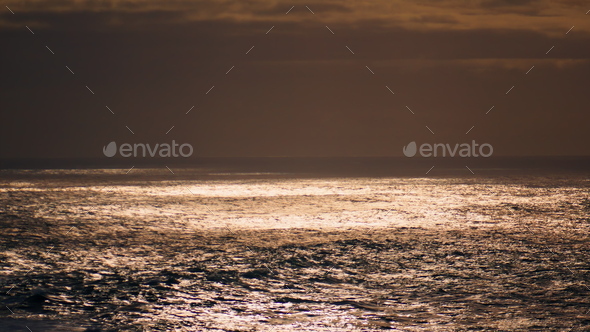 Ocean surface reflecting sunlight at cloudy sky. Peaceful endless sea ...