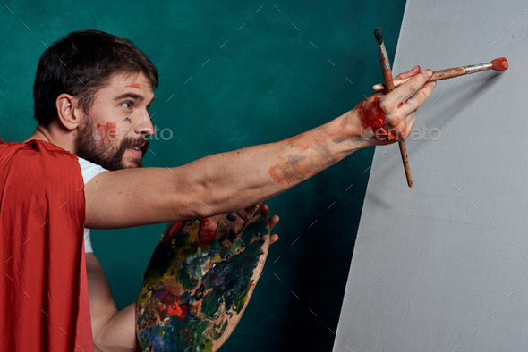Male artist red cloak drawing easel art green background image Stock ...