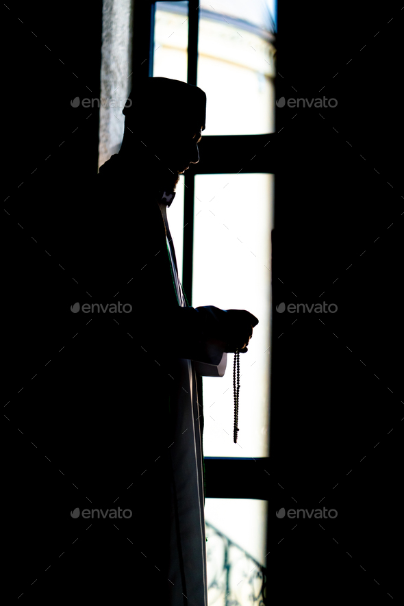 Silhouette of an Arab priest who stands in a mosque in national clothes ...