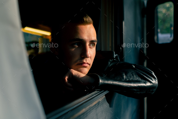 man in a leather jacket is driving trailer on a trip and looks ...