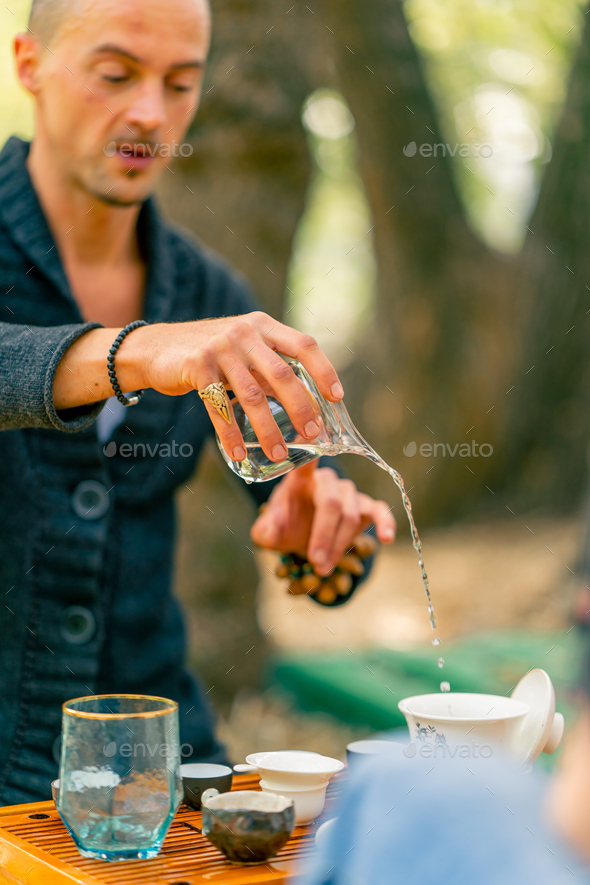 tea master using a traditional tea ceremony kit to pour boiling water ...