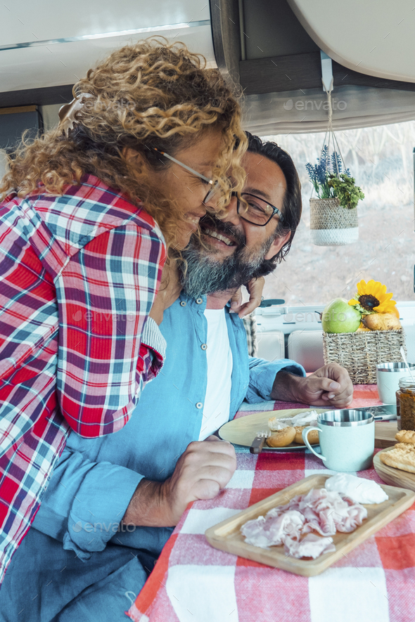 Happy traveler couple hug with love and fun together inside a camper ...