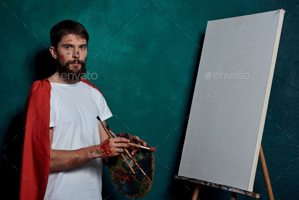 Male artist red cloak drawing easel art green background image Stock ...