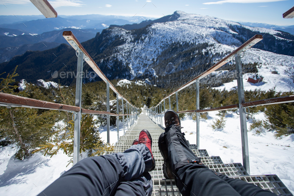Leggs of two traveller on the ladder with stairs in the winter ...