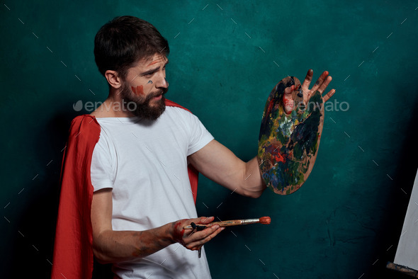 Male artist red cloak drawing easel art green background image Stock ...