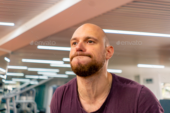 stressed face of a bodybuilder doing strength exercises with a barbell ...
