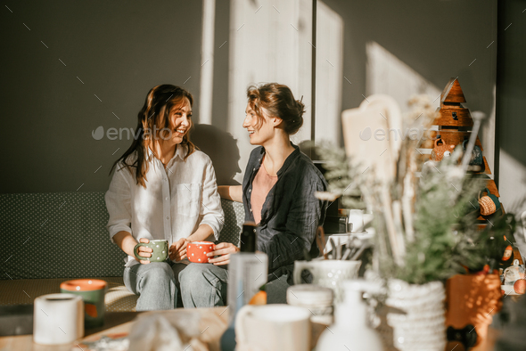 Two women drinking tea in the sunshine in cozy environment Stock Photo ...