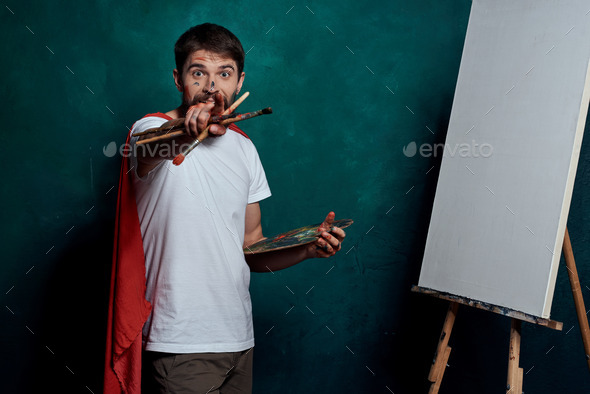 Male artist red cloak drawing easel art green background image Stock ...