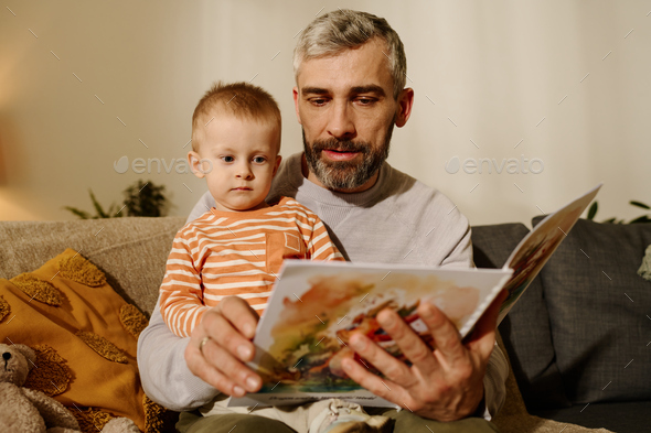 baby boy looking at page of open book Stock Photo by Pressmaster ...