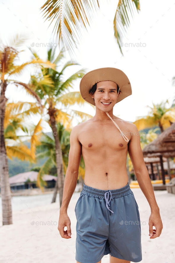 Muscular Asian Man Smiling on a Tropical Beach, Embracing the Summer ...