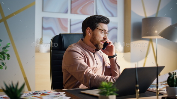 Busy corporate employee calling mobile phone working at office desk ...