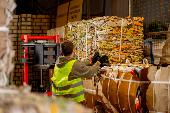 employee using stacker takes out paper box with used items to be ...