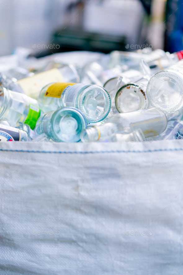 Close-up glass bottles packed in a special garbage bag at waste ...