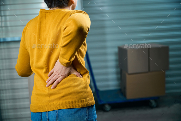 Lady in the pavilion clutched her sore lower back Stock Photo by Iakobchuk