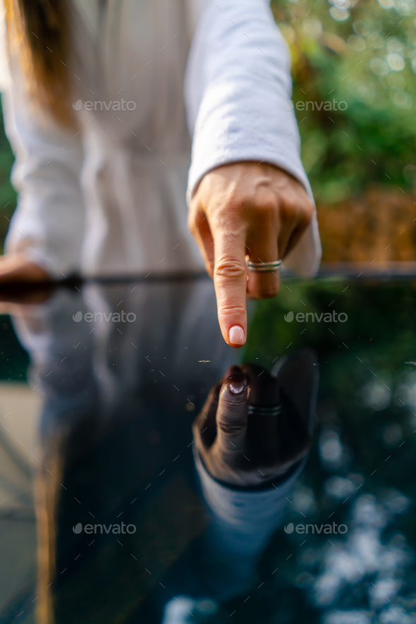 Close-up shot of hands being lowered into the water to check the water ...
