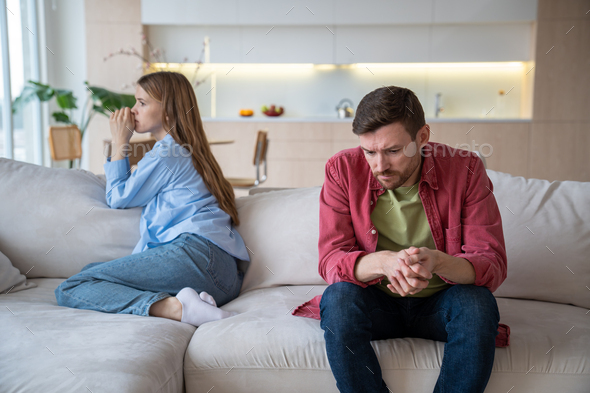 Couple man woman ignoring each other sitting on couch in silence at ...