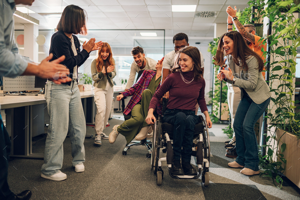 Young business woman who uses wheelchair racing in an office chair race ...