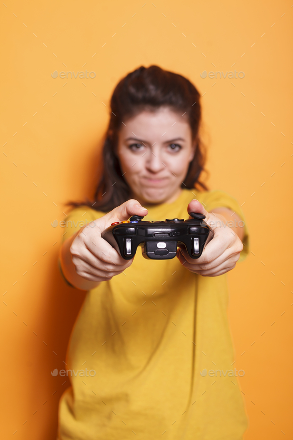 Female gamer holding wireless controller Stock Photo by DC_Studio ...