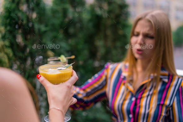 Close-up of friends toasting with cocktails on the summer terrace in ...
