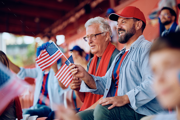 USA sports fans waving with flags while spectating a match from stadium ...