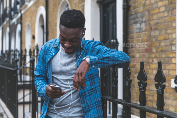 Black man listening music with phone in London Stock Photo by ...