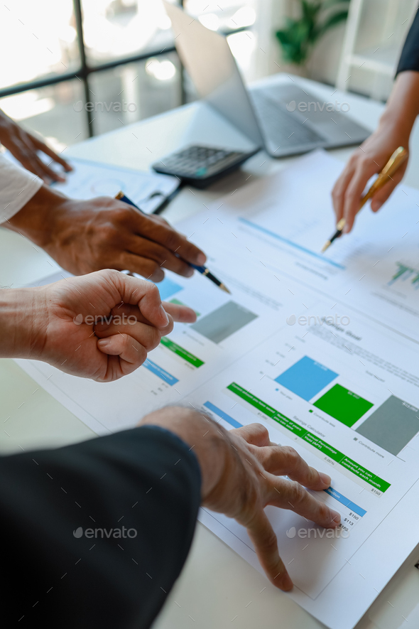 Mixed group of business people sitting around a table and working ...