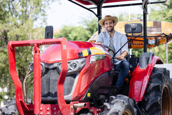 Farmer driving tractors pulling trailers for touring in farmland. Stock ...