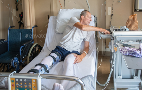 man with broken leg in an orthosis on bed in a clinic after an accident ...