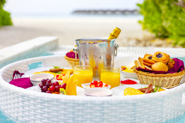 served floating tray in swimming pool with drinks and snacks on ...