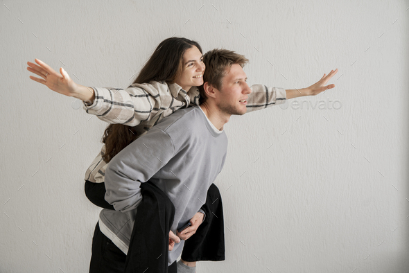 Strong Man Carrying His Partner on His Back in a Loving Gesture, woman spread hands Stock Photo ...